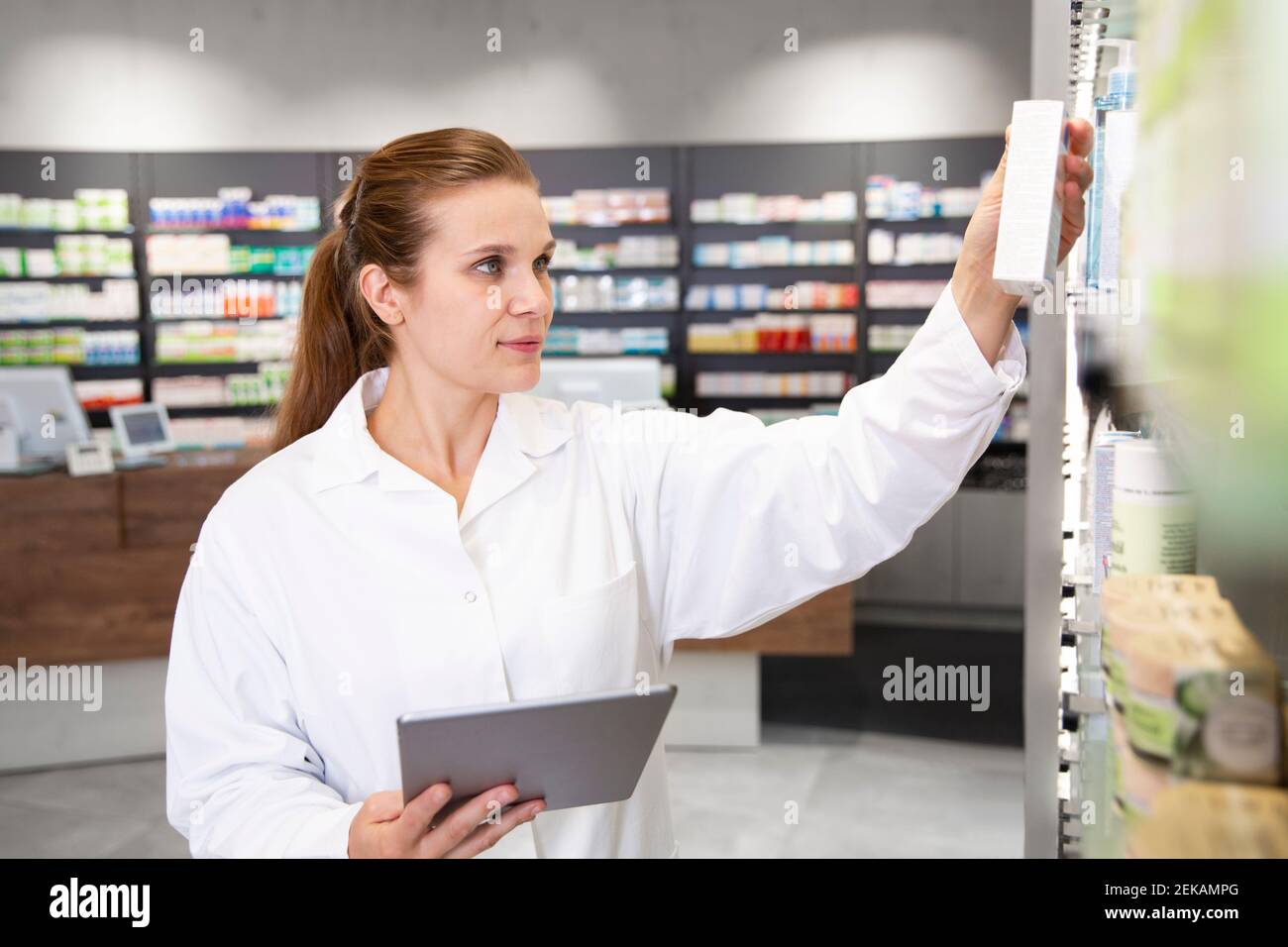 Female pharmacist with digital tablet checking medicine in store Stock ...