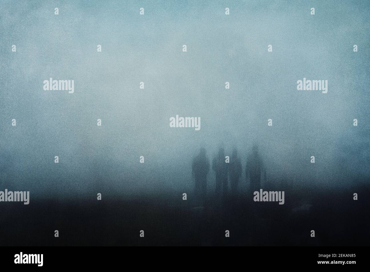 A spooky concept. Four blurred ghostly figures walking into the fog ...