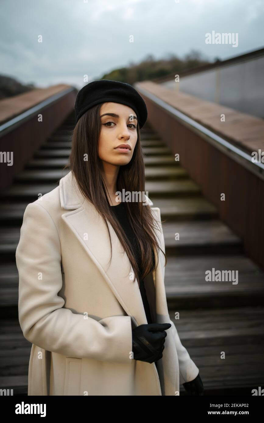 Beautiful woman wearing overcoat standing on steps Stock Photo - Alamy