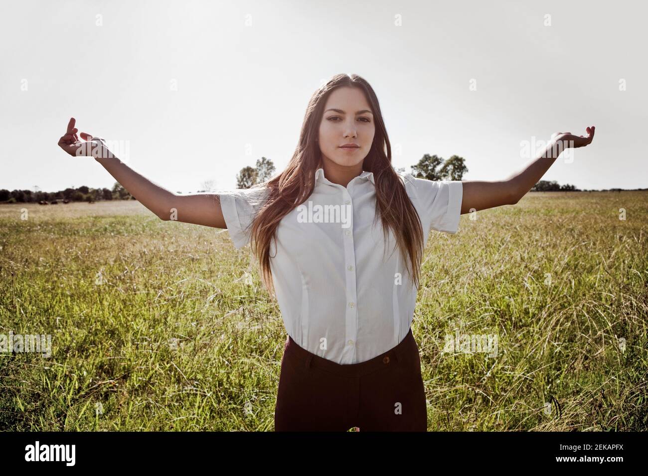 Teenage girl standing in a field with her arms outstretched Stock Photo ...