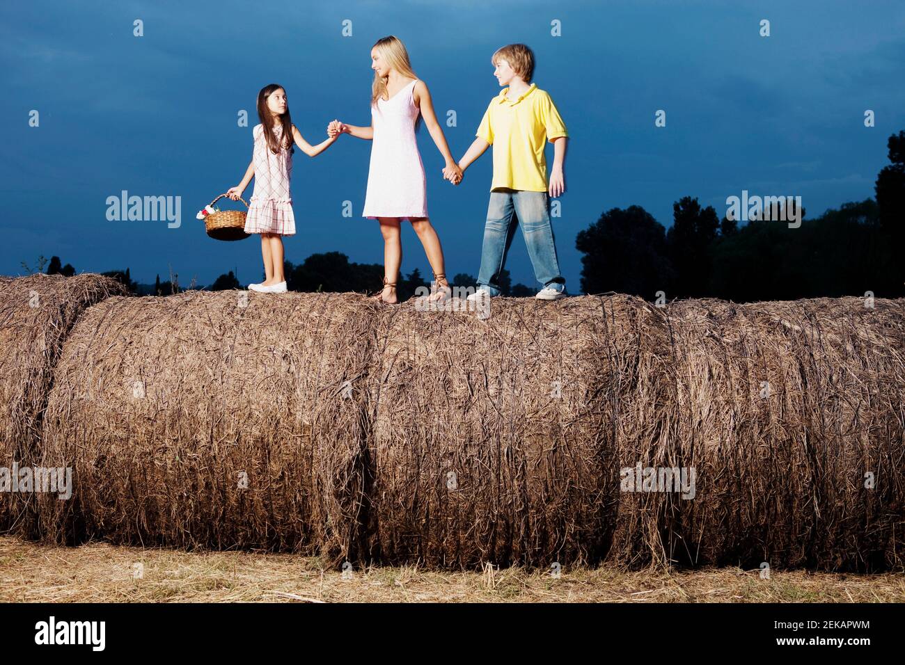 Woman walking with her two children on a haystack Stock Photo - Alamy