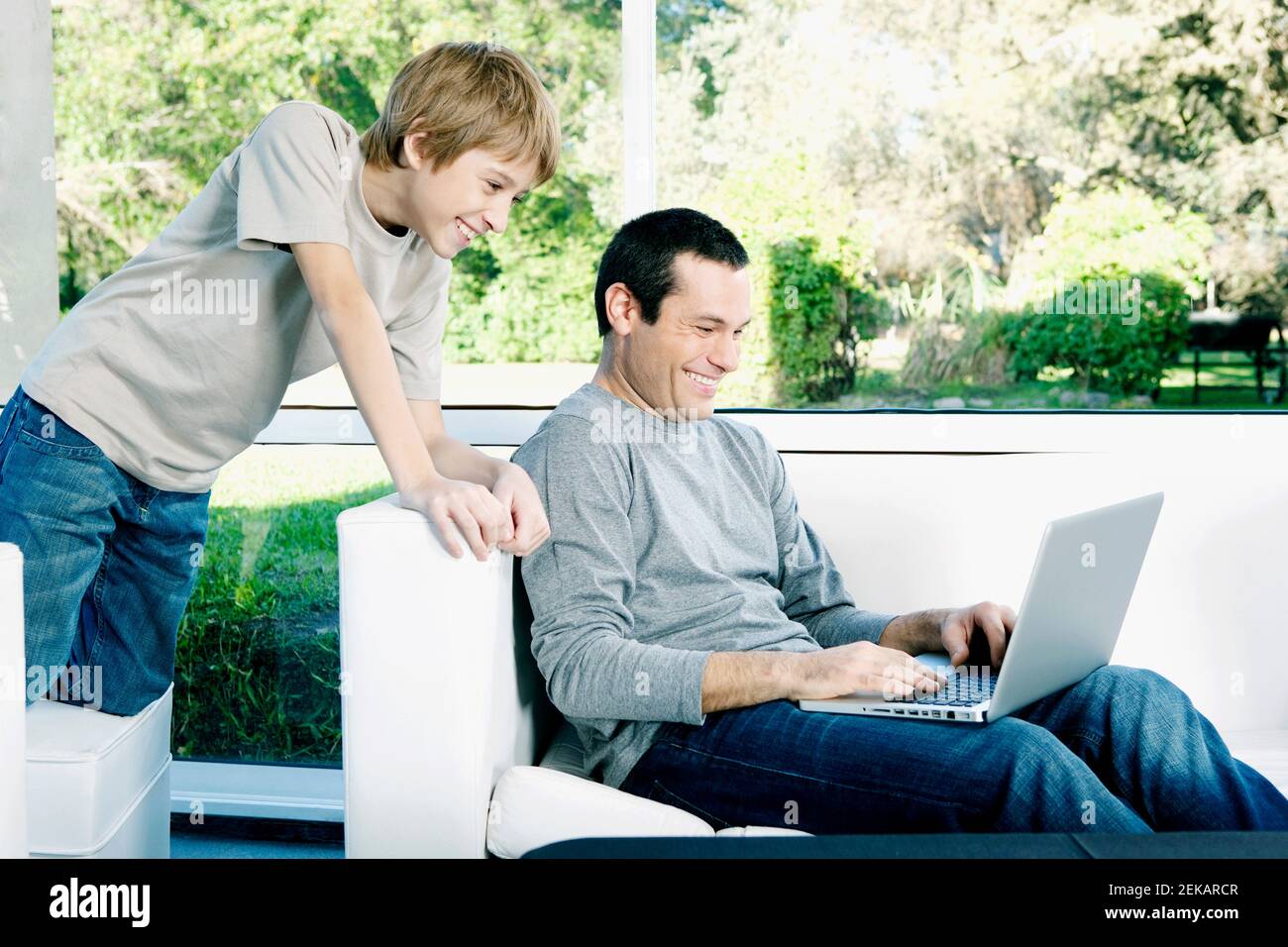 Man using a laptop with his son Stock Photo - Alamy