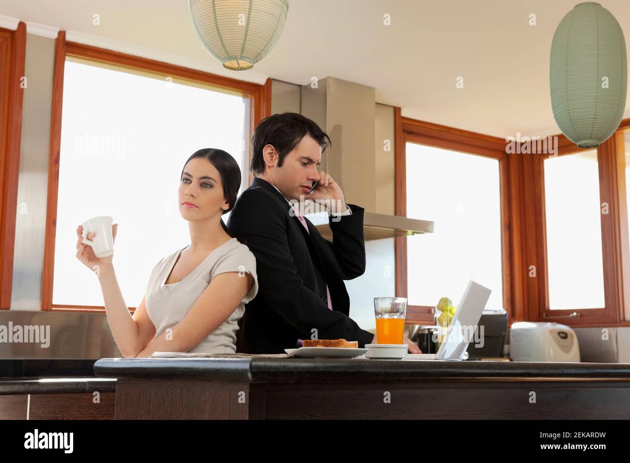 Distracted couple at breakfast table Stock Photo - Alamy
