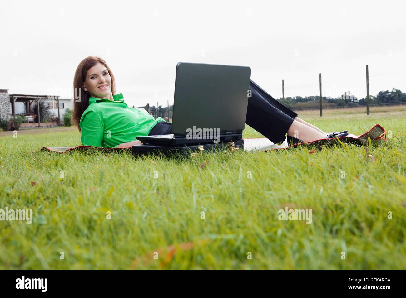 Woman lying in a field Stock Photo - Alamy