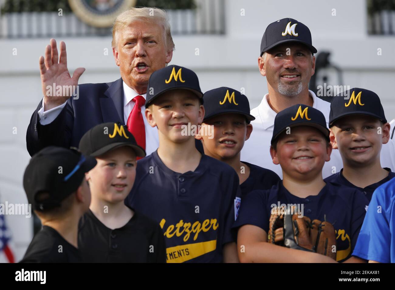 U.S. President Donald Trump poses for a group photo with young players ...