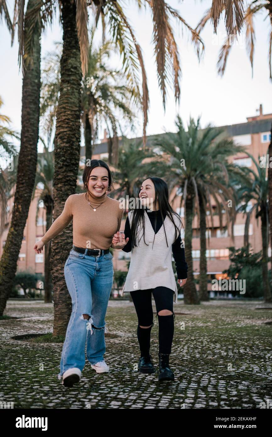 Two girls running holding hands hi-res stock photography and images - Alamy