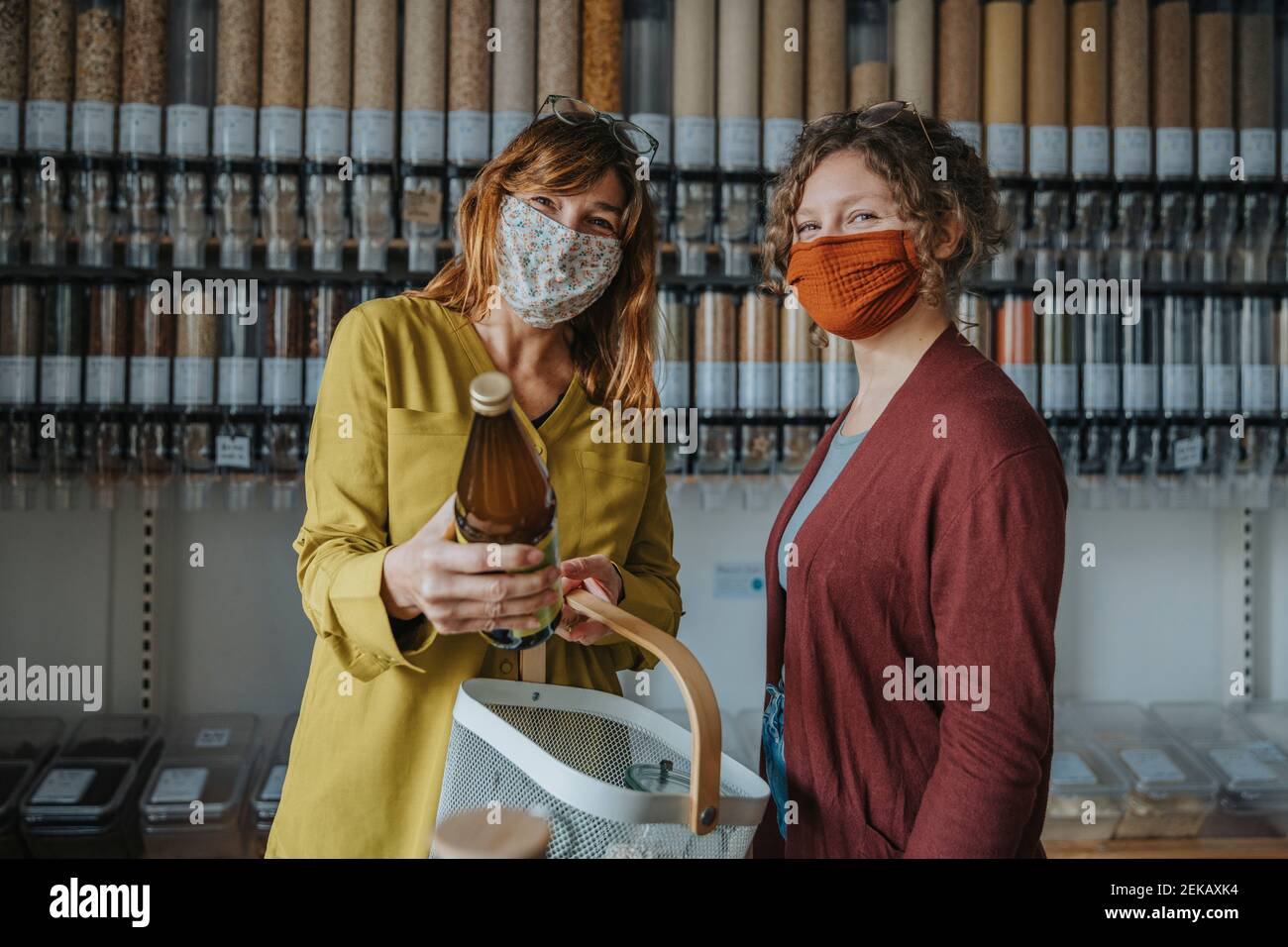 Female friends in mask shopping together in retail store Stock Photo ...