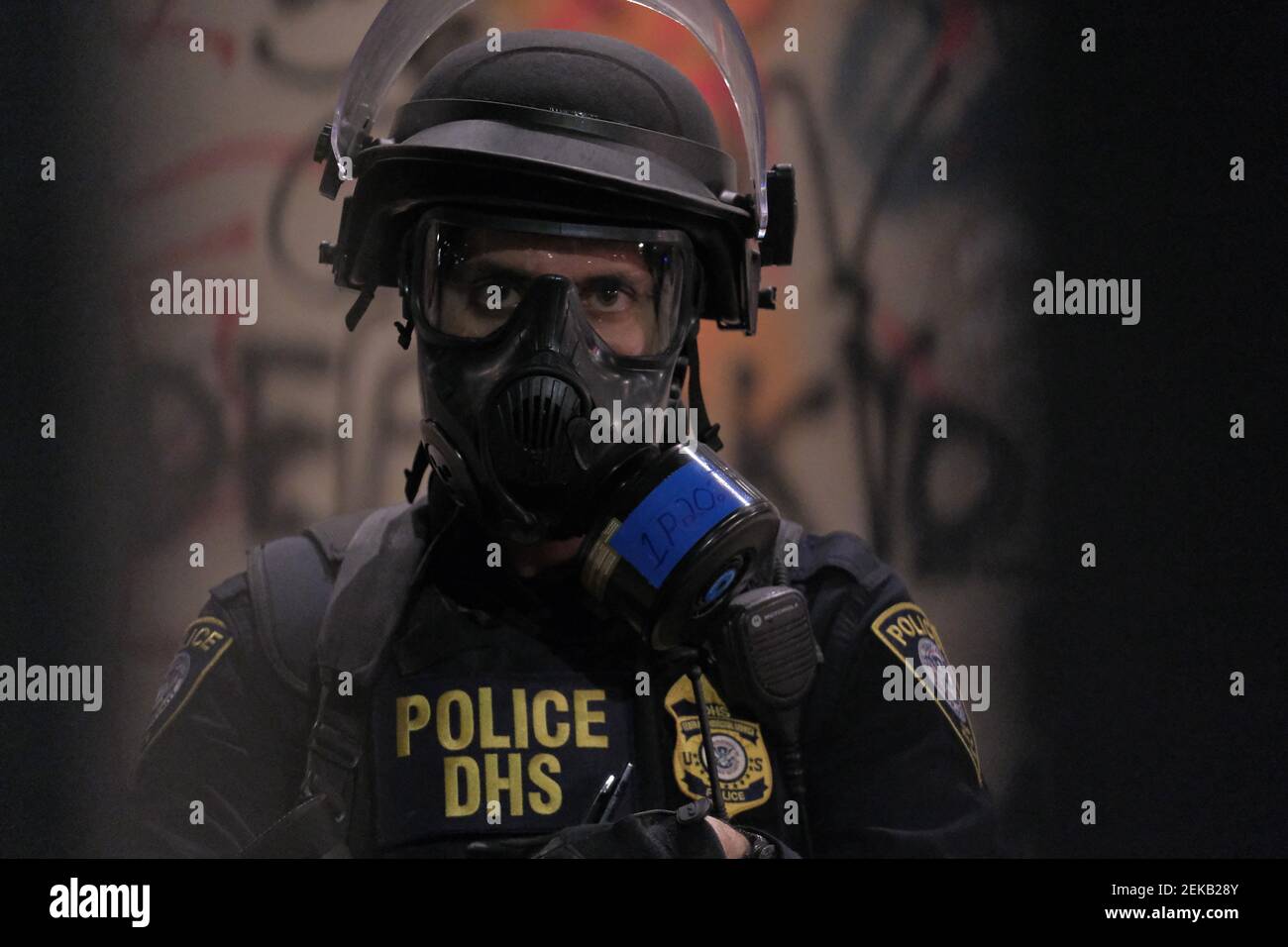 A federal officer monitors the scene outside the federal courthouse in ...