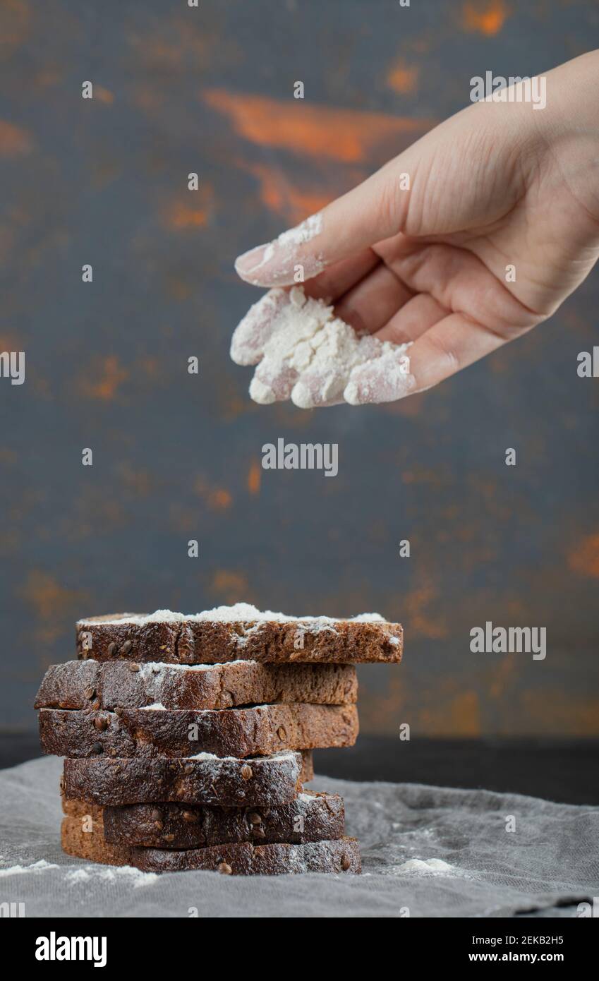 Female hand pouring a pinch of flour on bread Stock Photo - Alamy