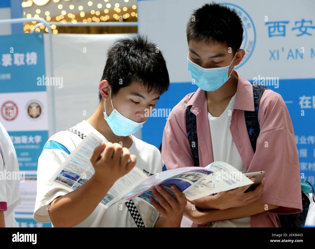 Two person read college promotion posters at the College Application ...