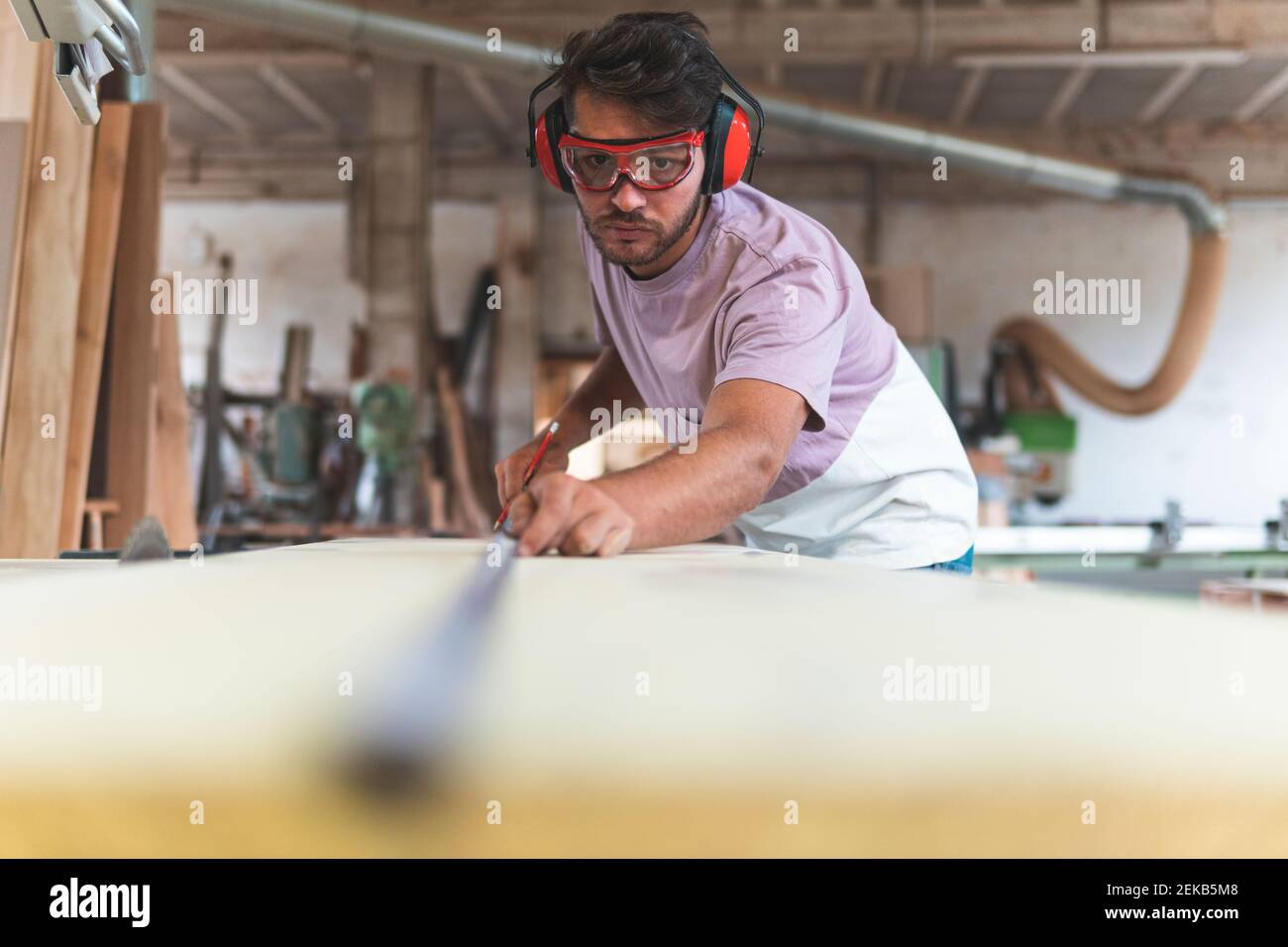 Male carpenter using tape measure while working in workshop Stock Photo ...
