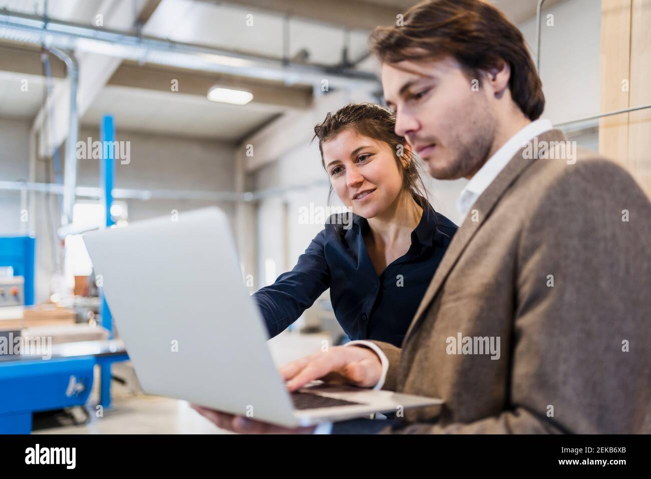Business people using laptop while working at industry Stock Photo - Alamy