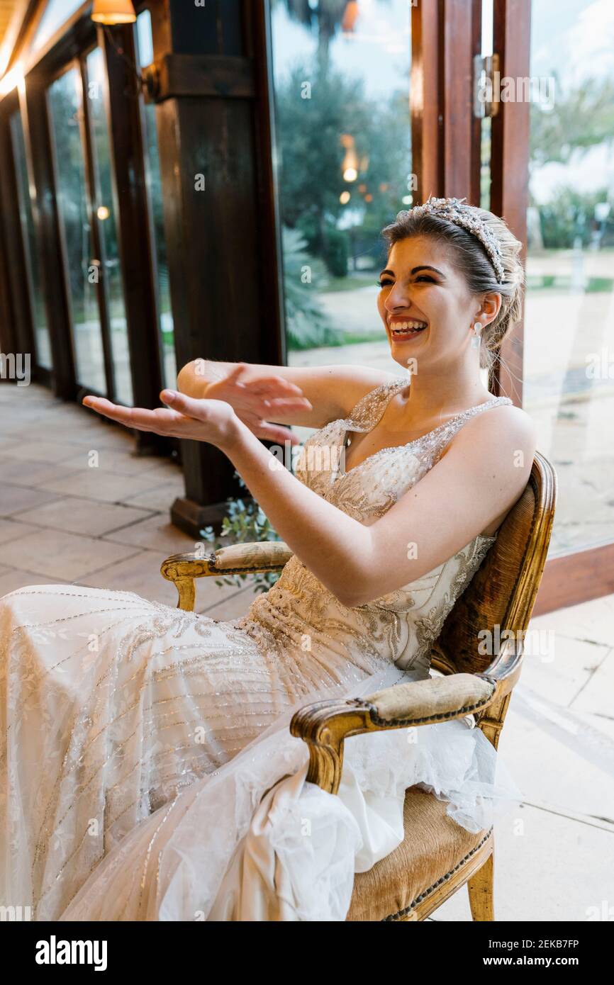 Happy bride clapping hands while sitting on chair at banquet Stock ...