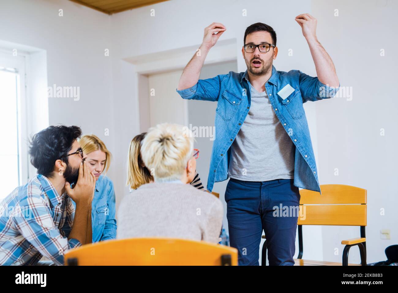 Group of people sitting in a circle on group therapy. One man is ...