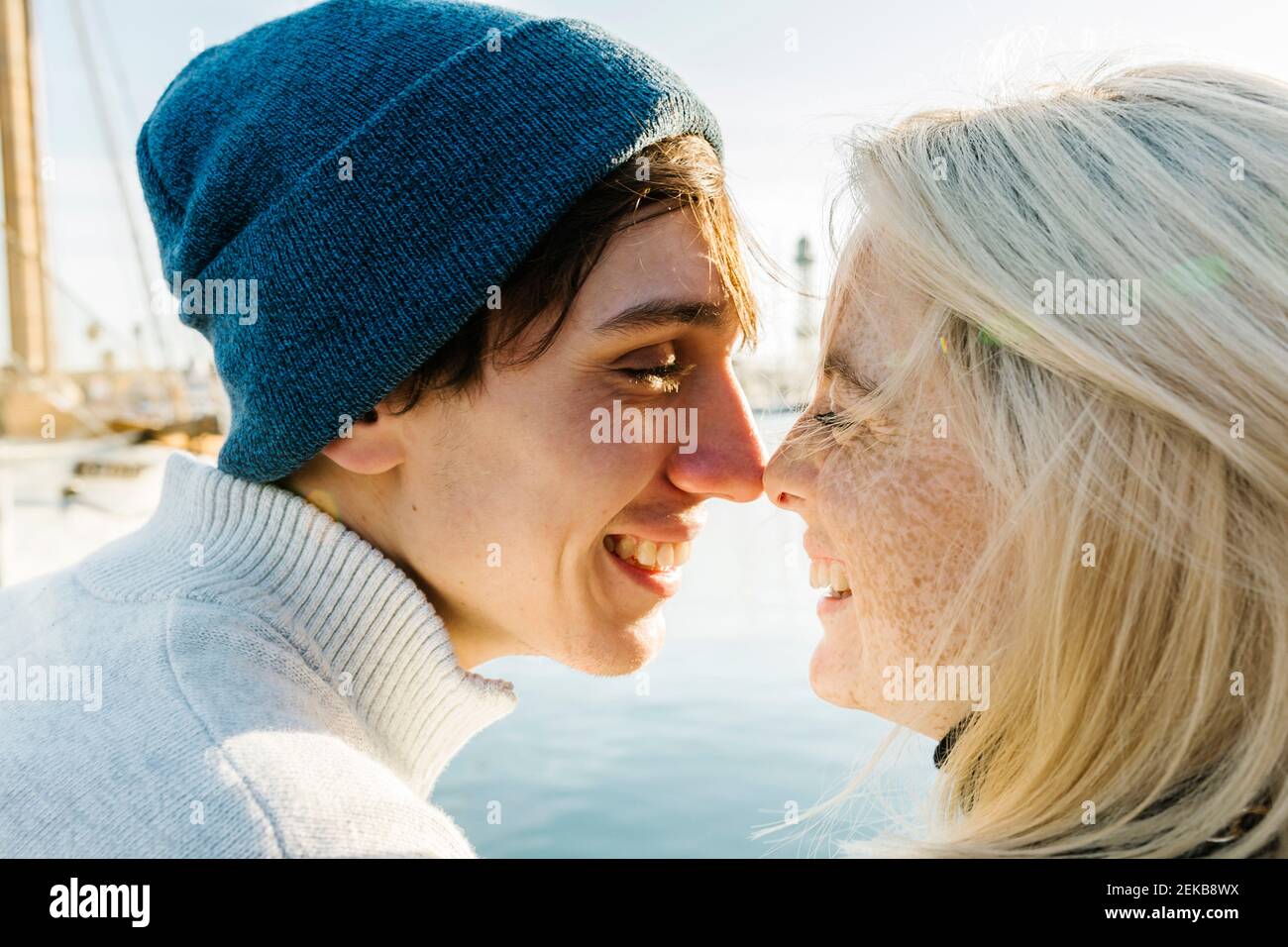 Smiling young couple face to face at harbor Stock Photo - Alamy