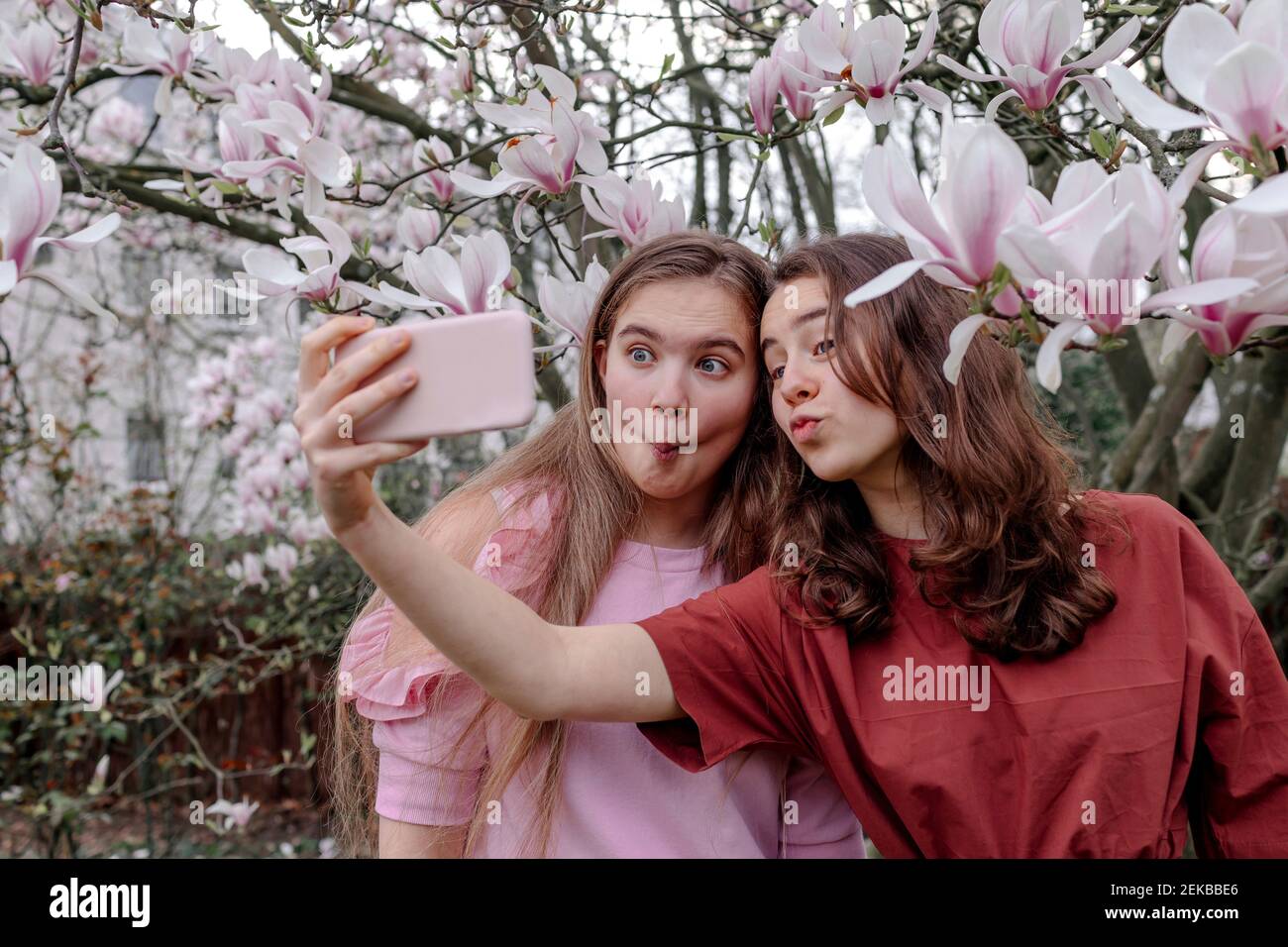 Female Friends Puckering While Taking Selfie Through Smart Phone Stock