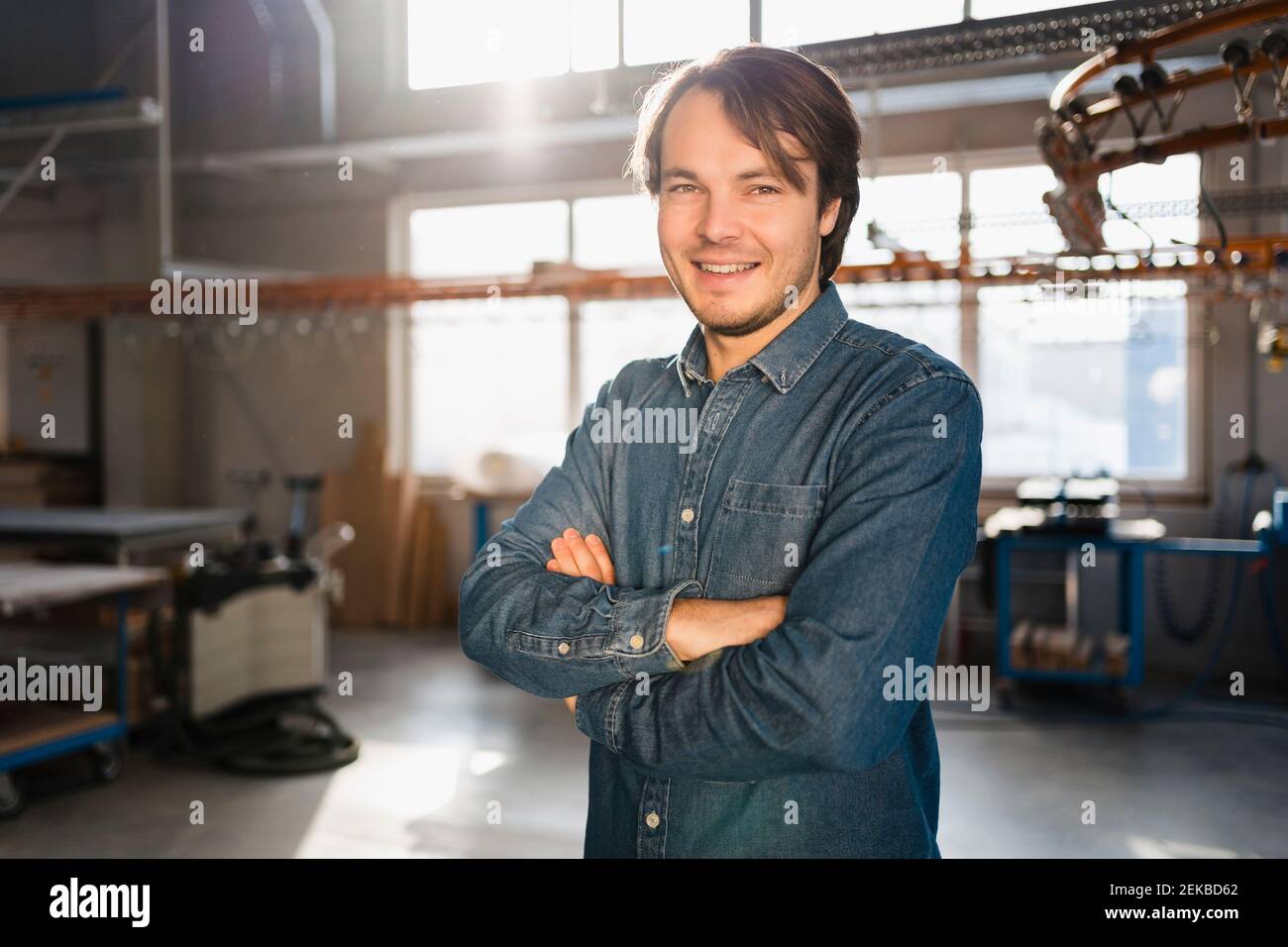 Male inspector with arms crossed standing at industry Stock Photo - Alamy