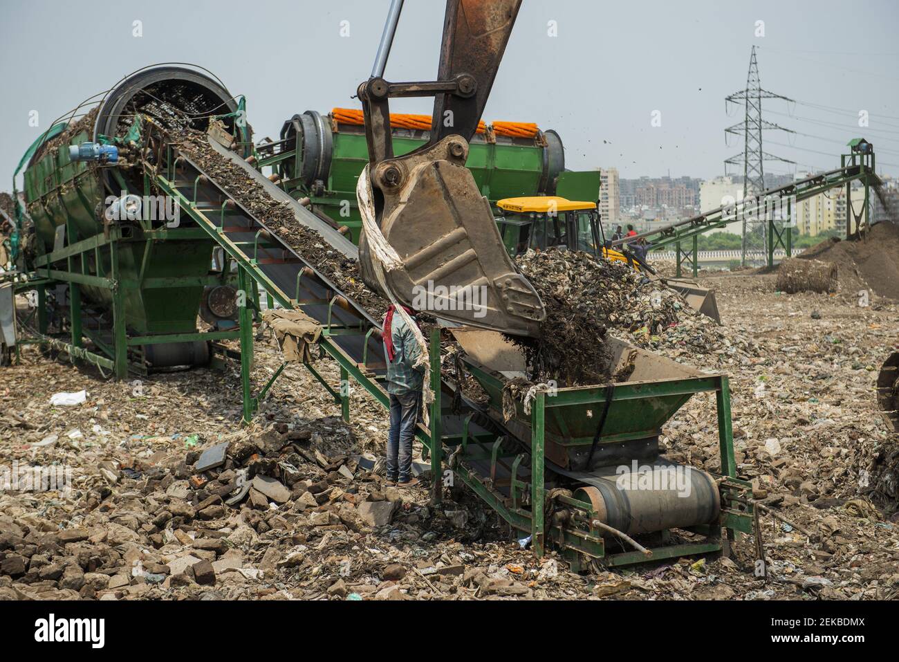 A JCB machine feeding waste in the plant for the segregation process ...