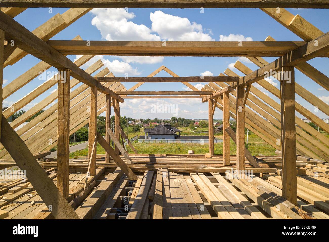 Aerial view of unfinished house with wooden roof frame structure under ...