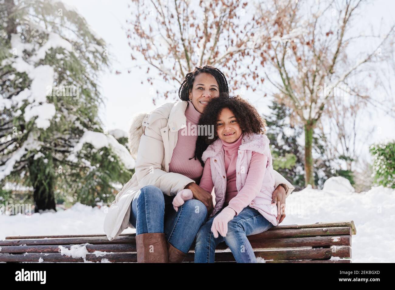 Mother and daughter sitting on bench in park Stock Photo - Alamy