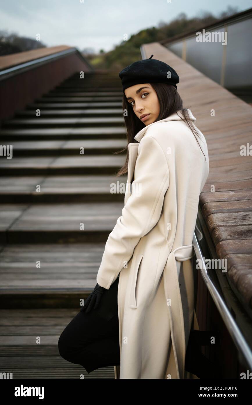 Young woman looking over shoulder while standing on staircase Stock ...