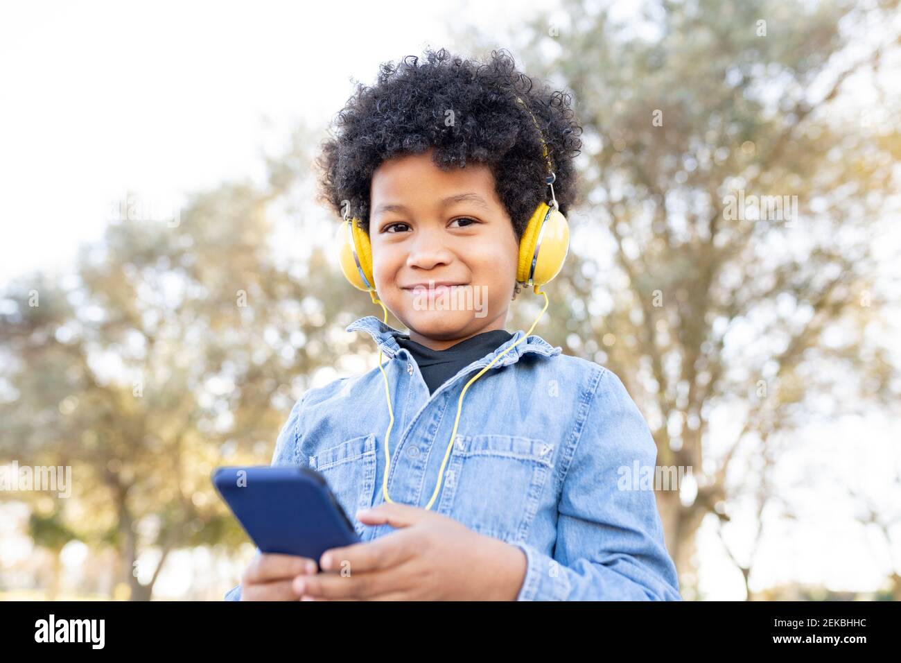 Boy looking at mobile phone standing hi-res stock photography and ...