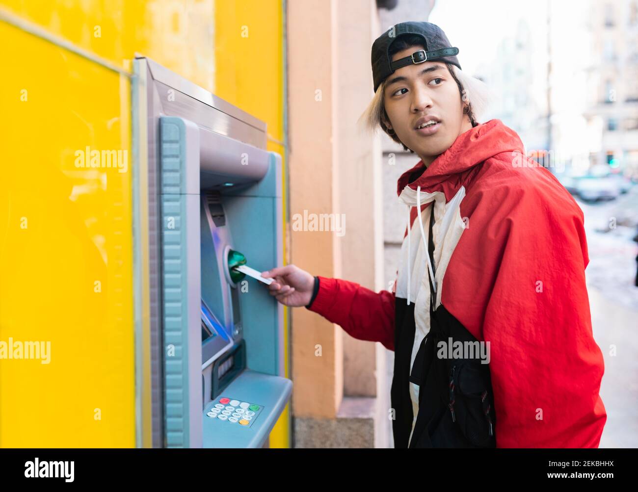 Asian man withdrawing money from ATM machine Stock Photo - Alamy