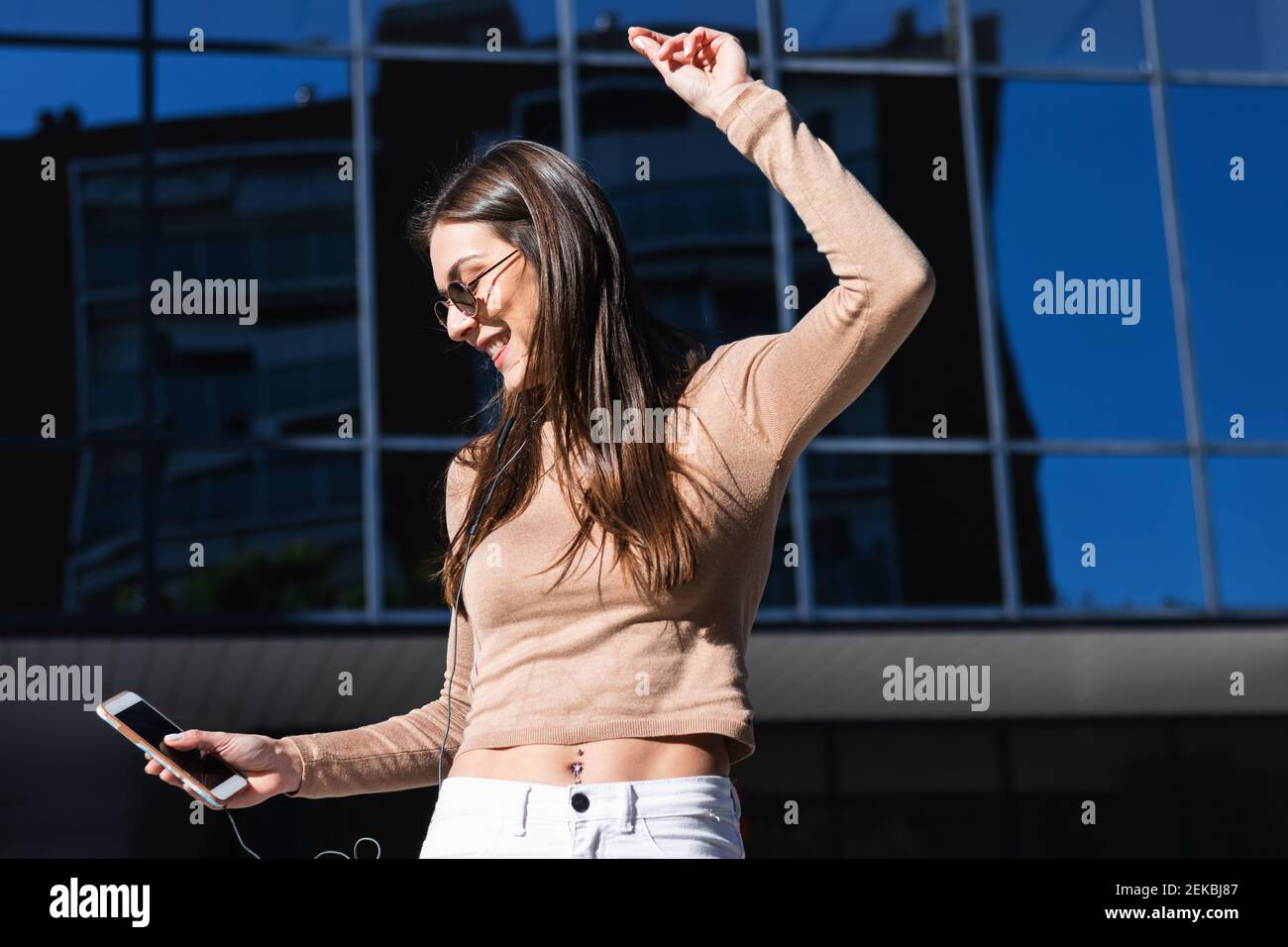 Young woman dancing holding smartphone hi-res stock photography and ...
