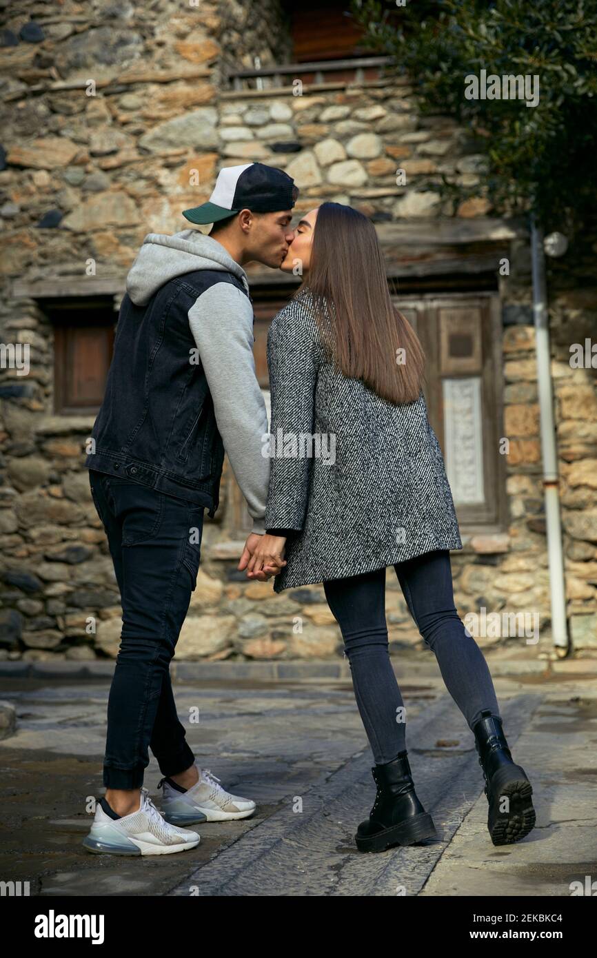 Romantic young couple holding hands while kissing on street Stock Photo - Alamy