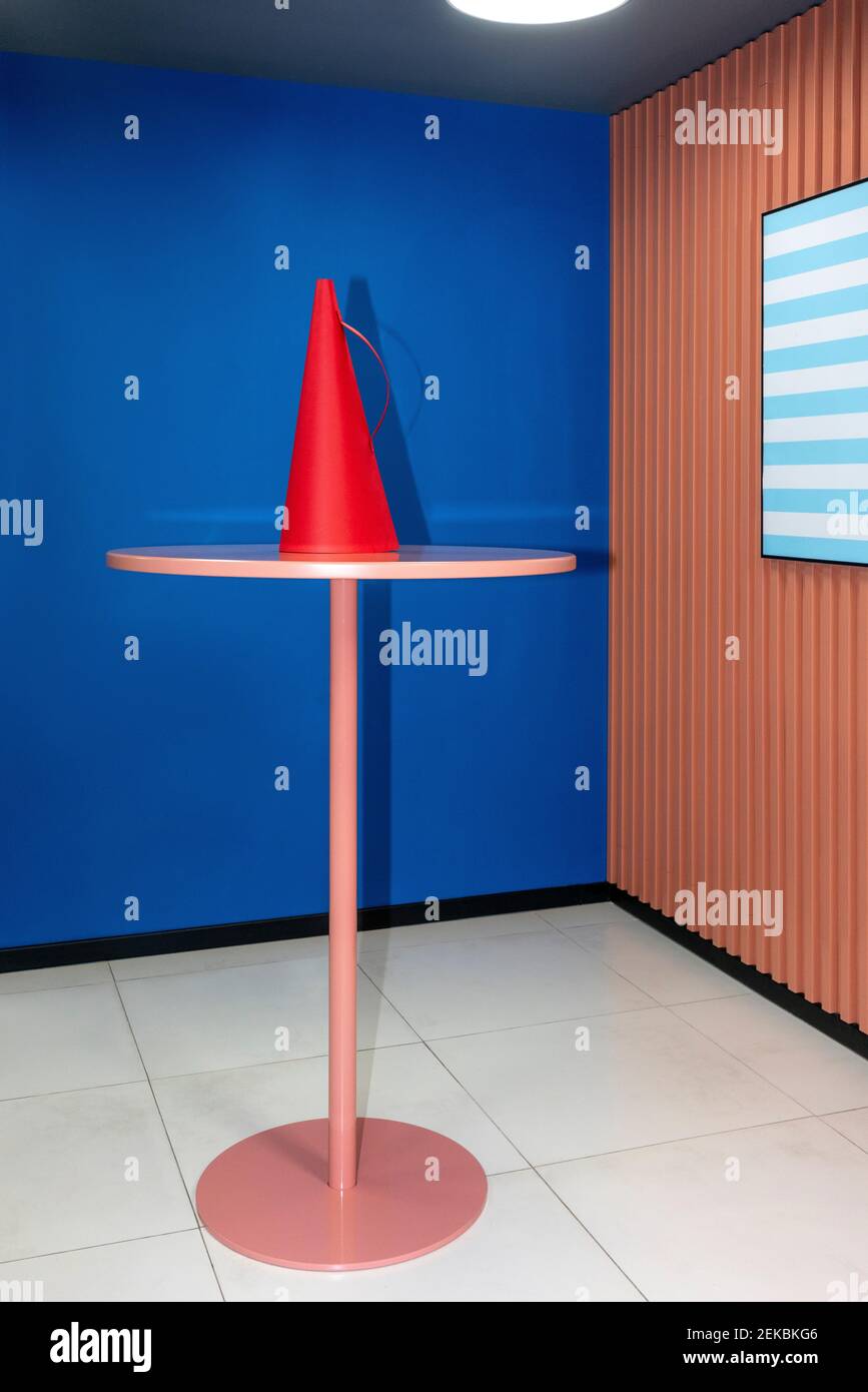 Red megaphone on table against blue wall at workplace Stock Photo - Alamy