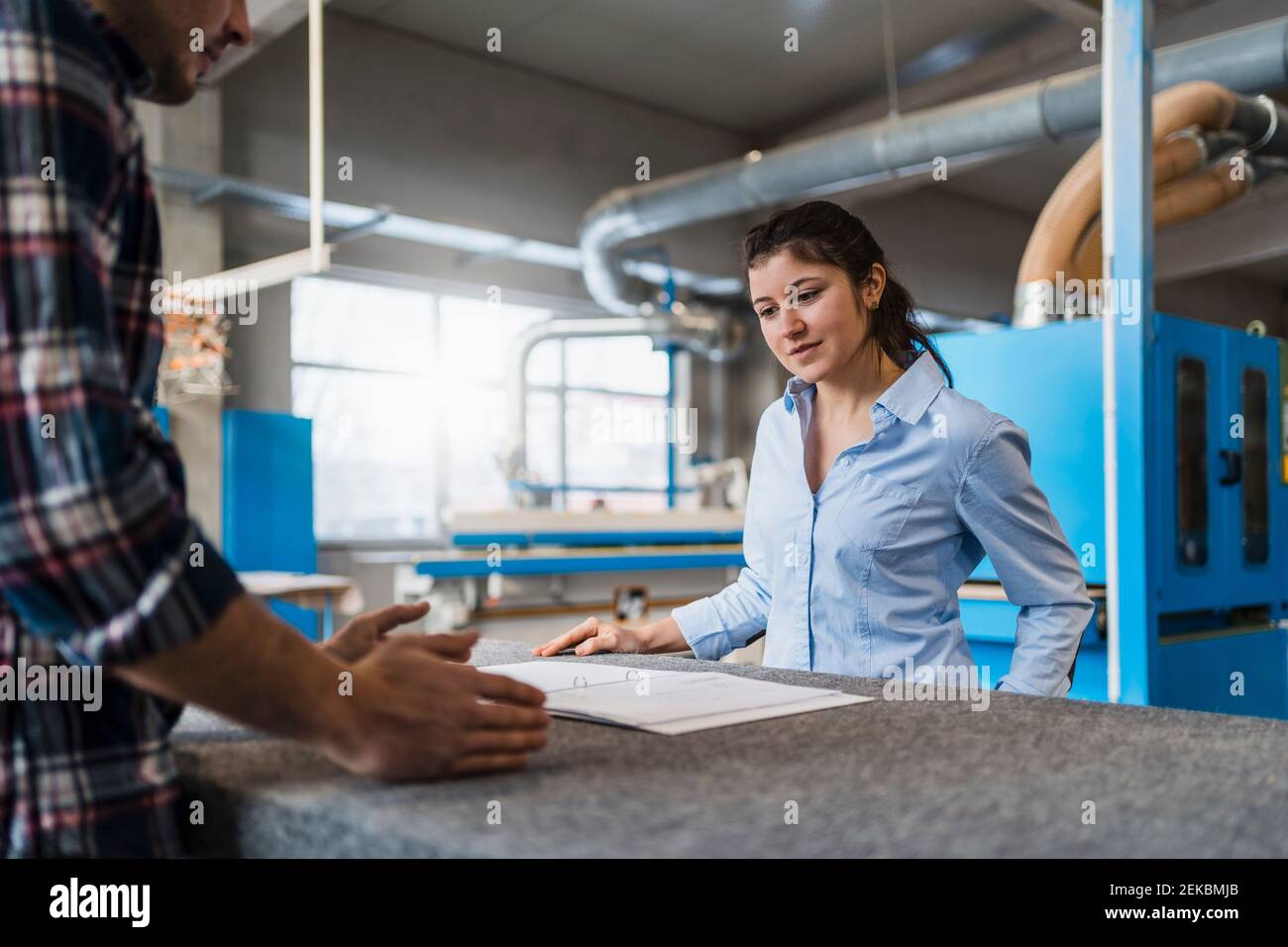 Businessman explaining over colleague to inspector while standing at ...