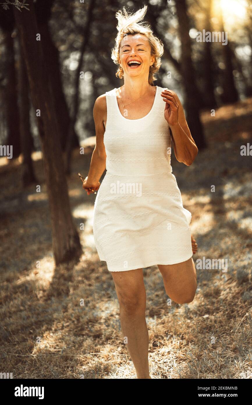Woman in dress running away into forest hi-res stock photography and ...