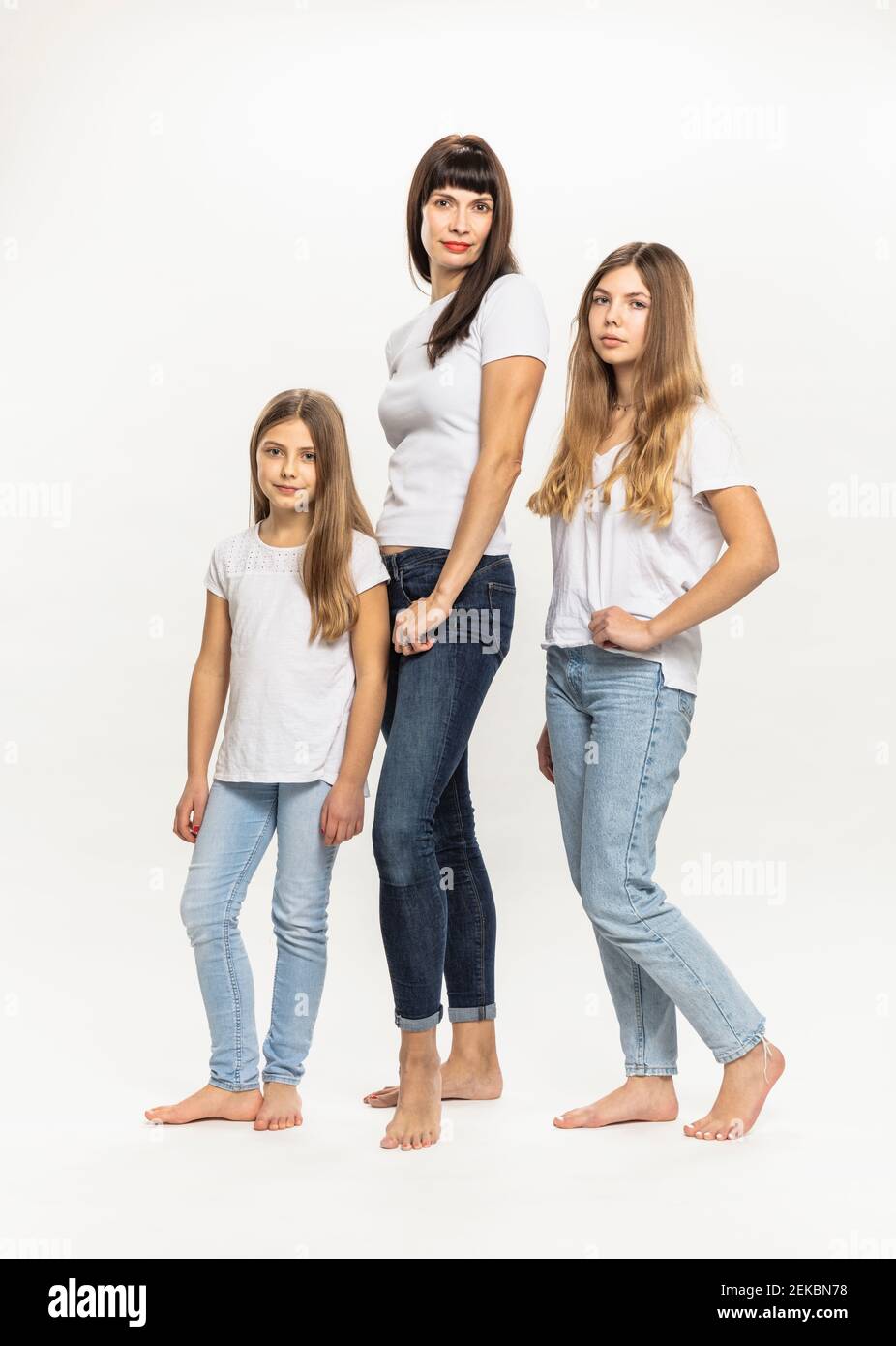 Mother standing with daughters against white background Stock Photo - Alamy