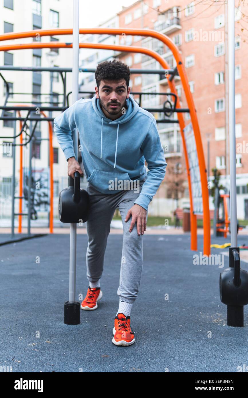 Athlete exercising with sports equipment while standing in training ...