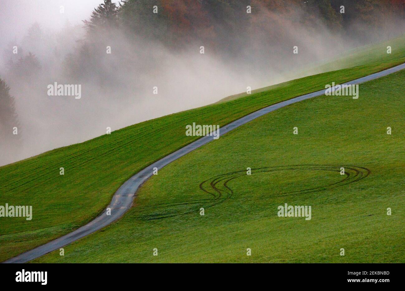 Fog floating over empty hillside road Stock Photo - Alamy