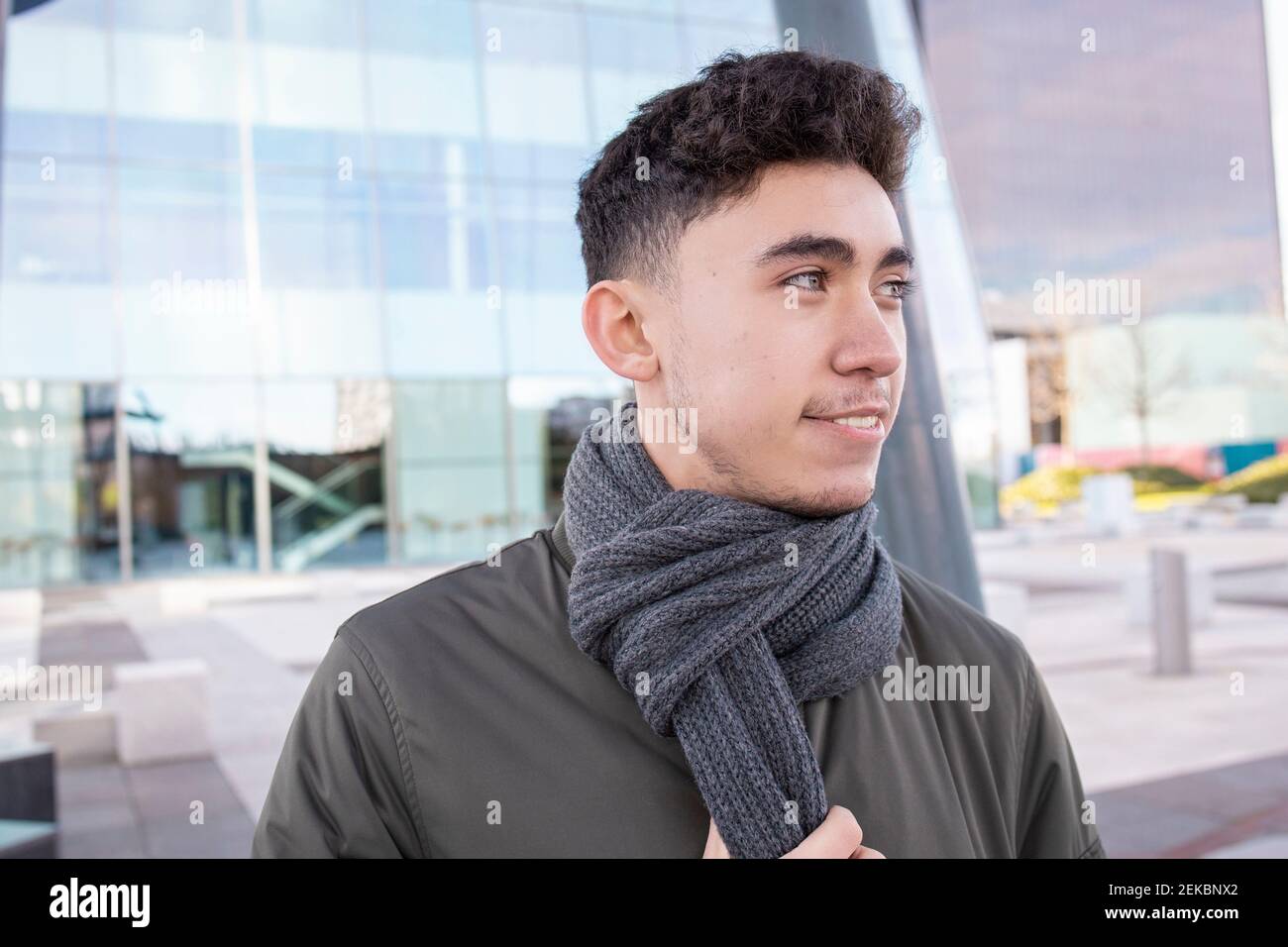 Smiling young in warm clothing contemplating in city Stock Photo - Alamy
