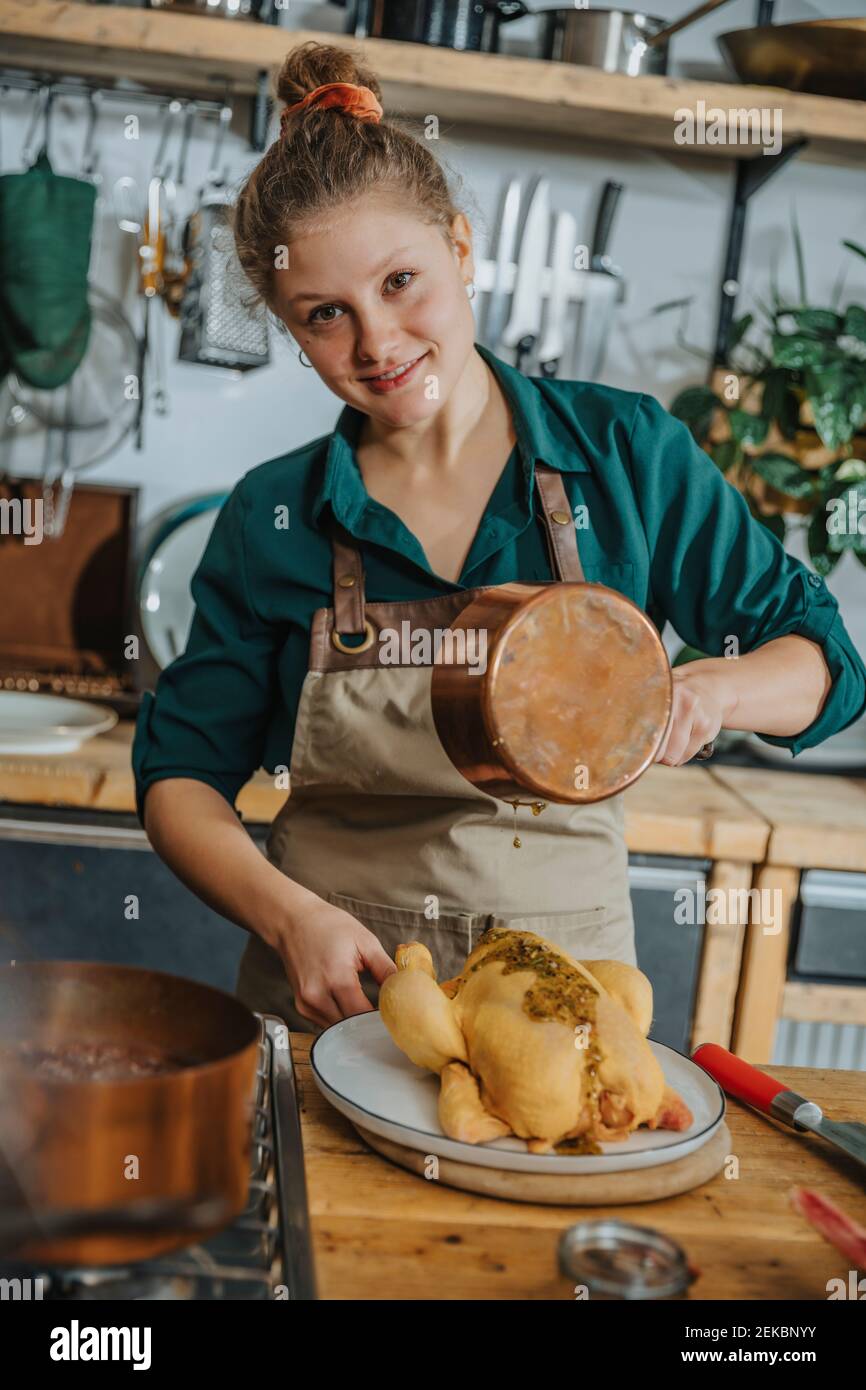 Female chef preparing chicken food while standing in kitchen Stock ...