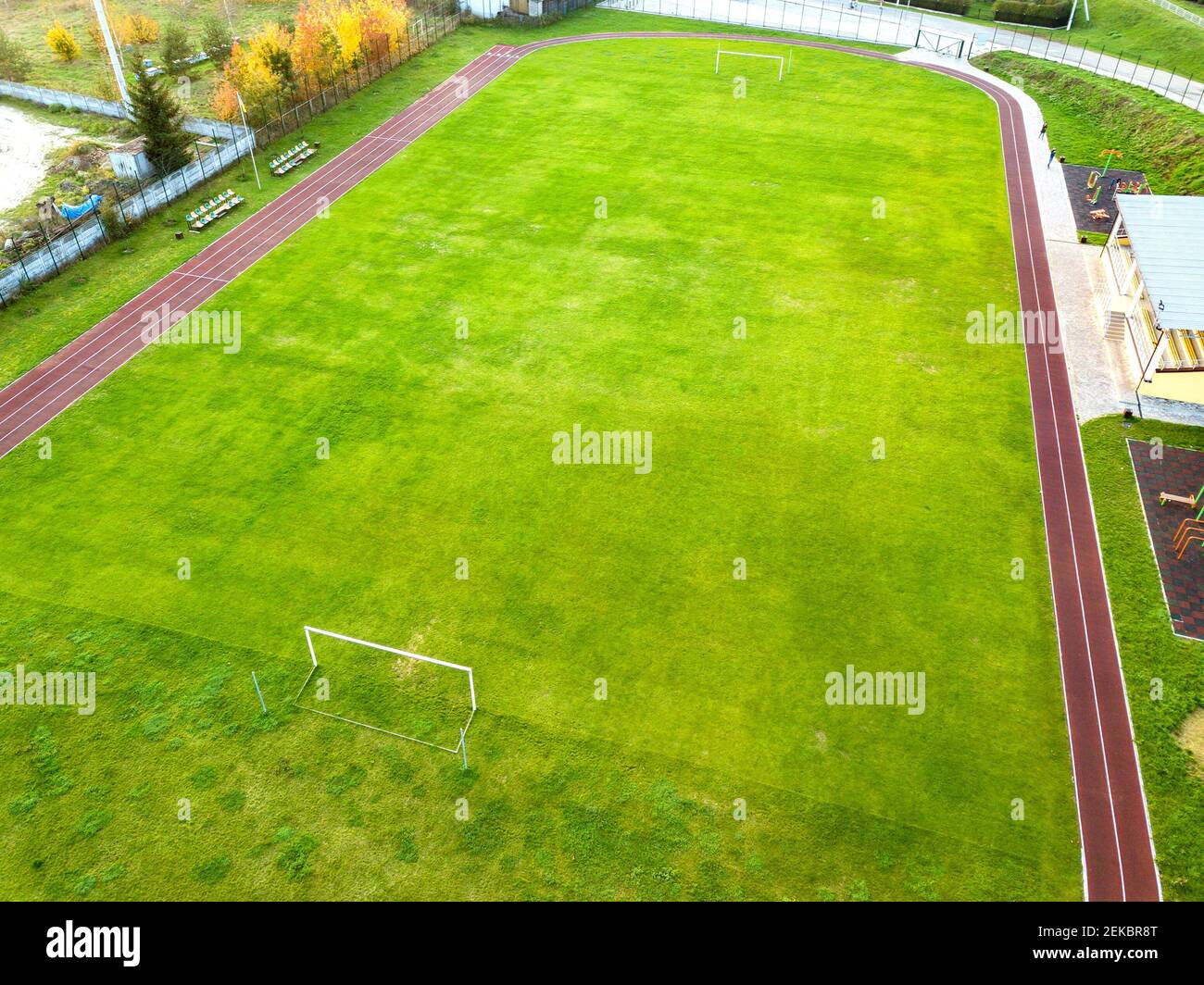 Aerial view of sports stadium with red running tracks and green grass ...