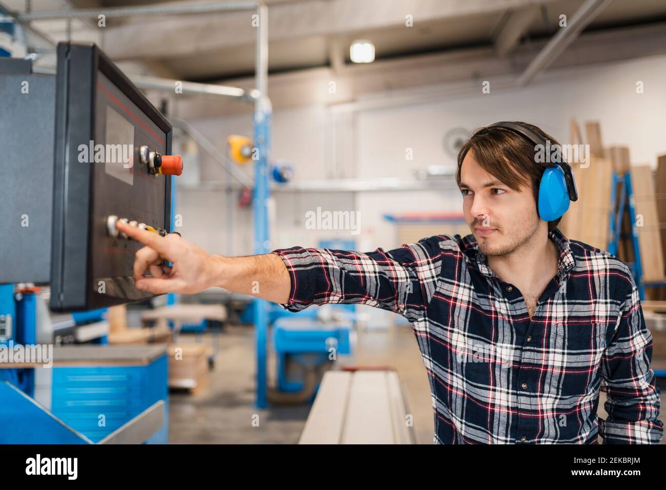 Industrial worker operating machine while standing at industry Stock ...
