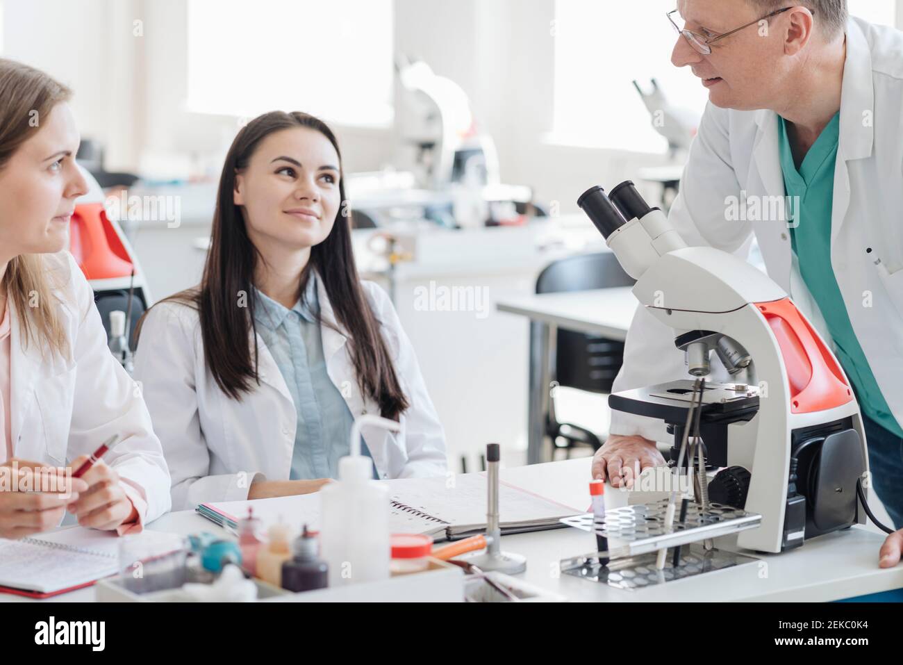Students and teacher talking in science class Stock Photo - Alamy