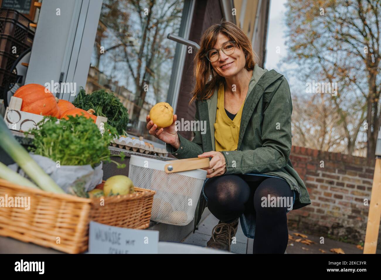 Smiling mature customer with basket shopping fruits at organic food ...