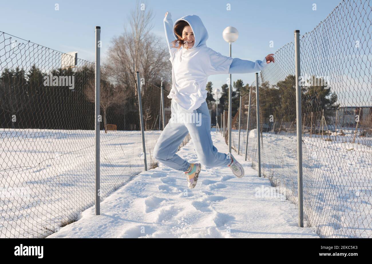 Young woman jumping fence hi-res stock photography and images - Alamy