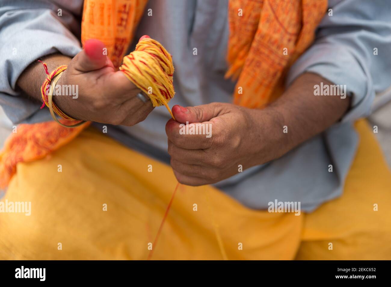 A priest arranging a sacred colorful thread during the festival at the ...