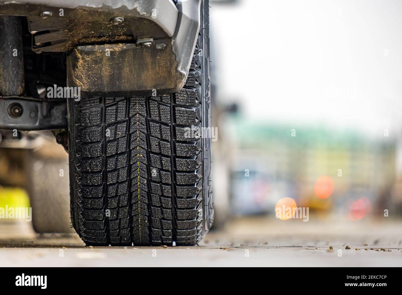 Closeup of parked car on a city street side with new winter rubber ...