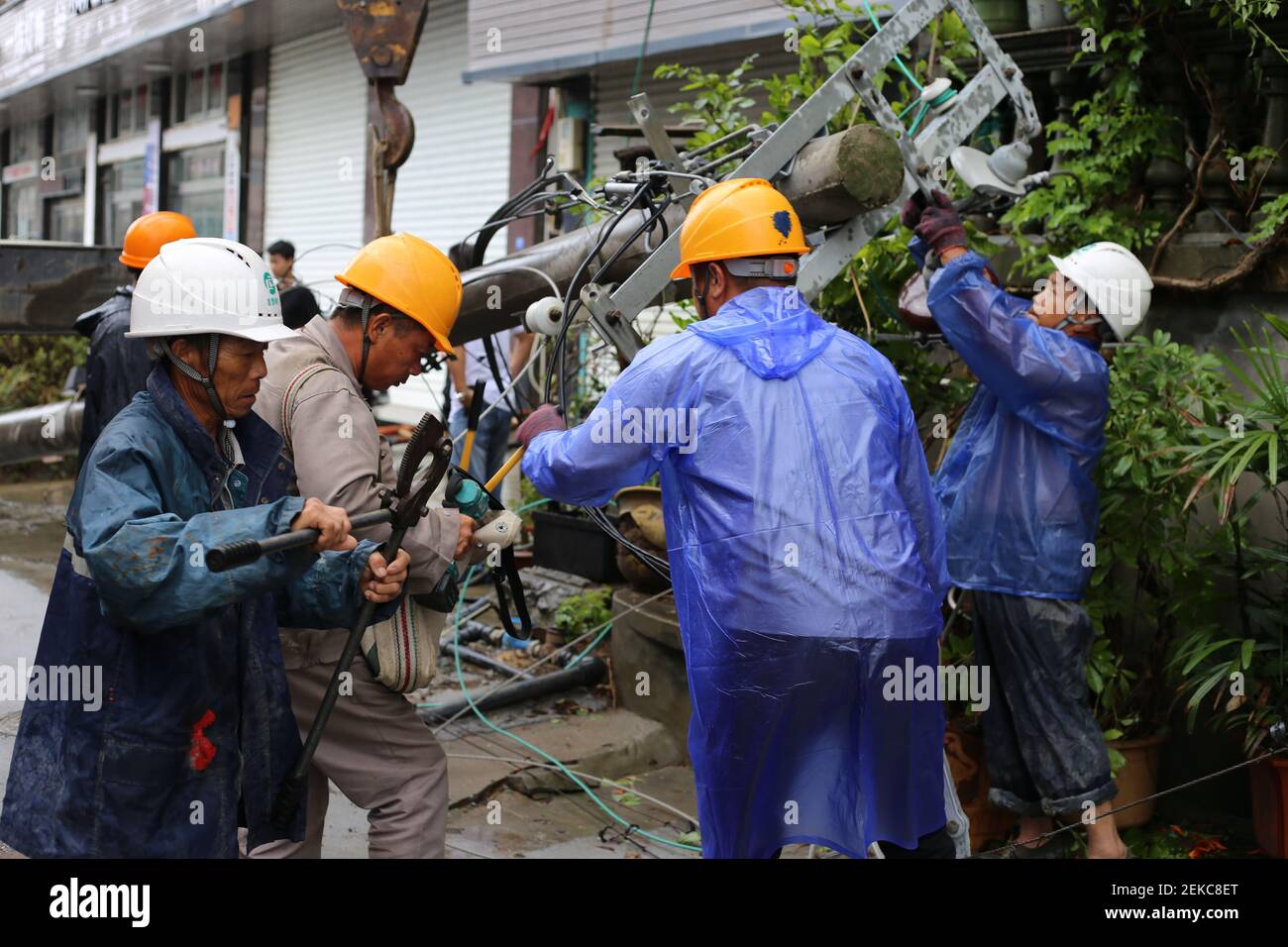 Staff from local electricity company are busy at repairing utility ...