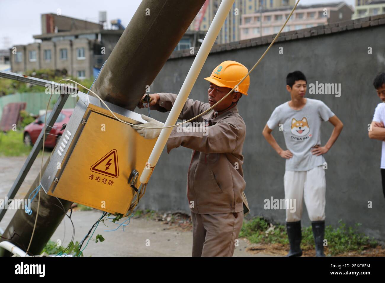 Staff from local electricity company are busy at repairing utility ...