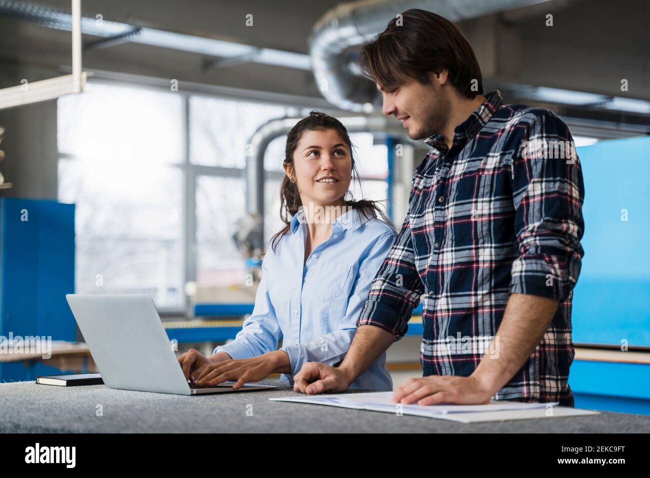 Expertise team working over laptop while standing at industry Stock ...