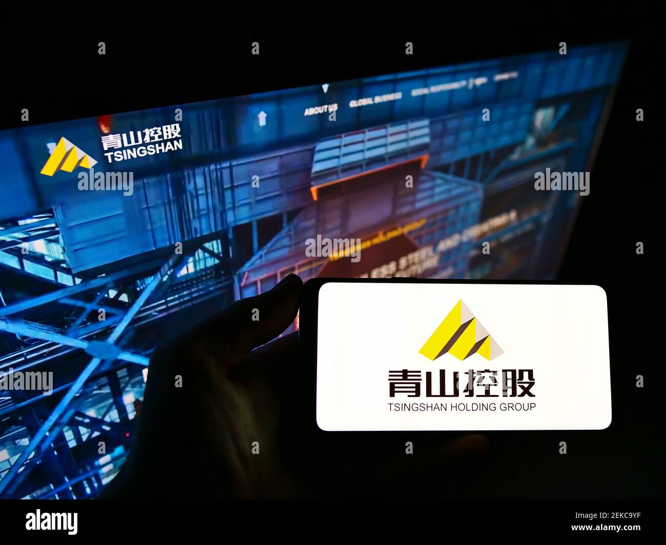 Person holding cellphone with business logo of Chinese mining company ...