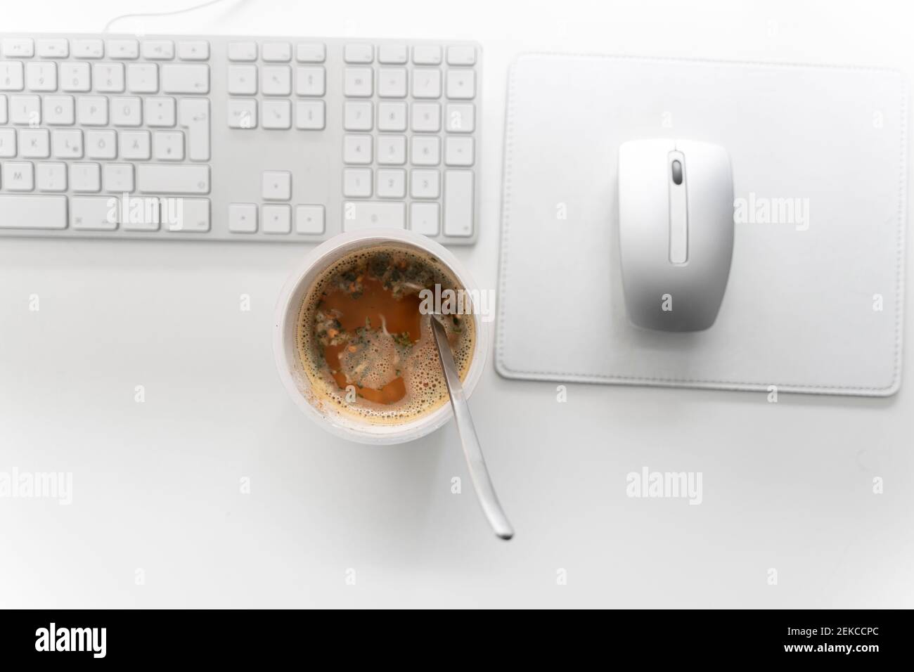 Instant noodles cup with computer keyboard and mouse on desk at home ...