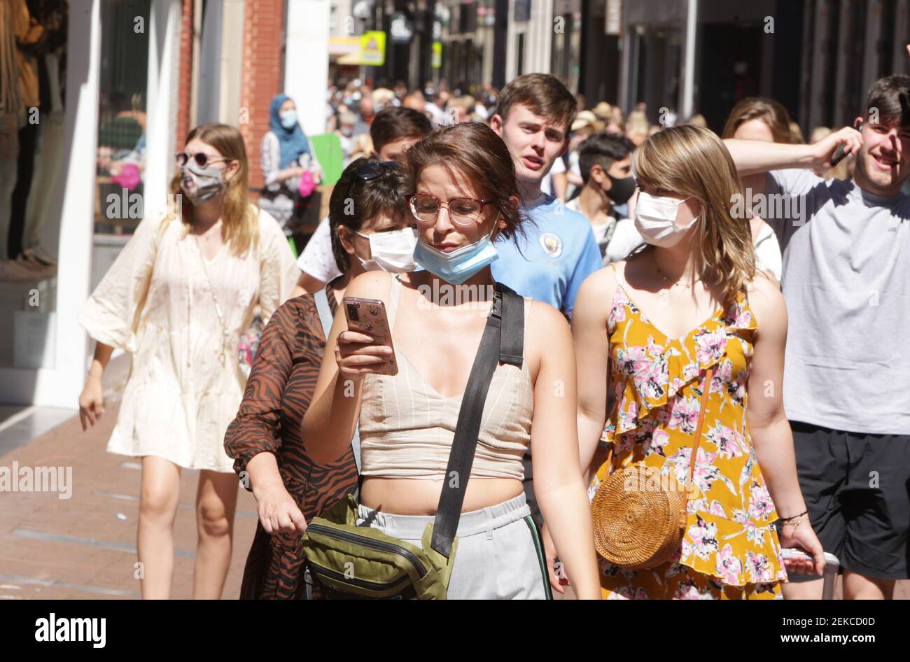 A woman puts the face mask down and checks her cell phone at the ...